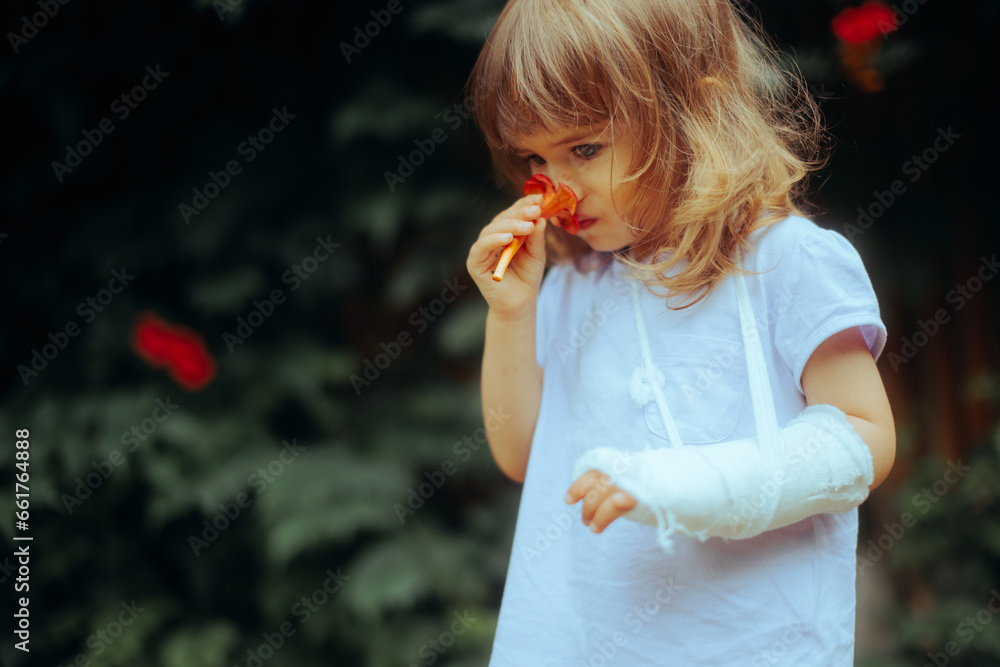 Girl with a Broken Arm in Orthopedic Plaster Smelling Flower. Child ...