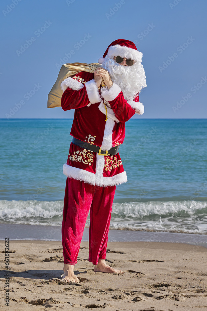 Santa Claus at sea on a hot summer day. Santa Claus stands barefoot on ...