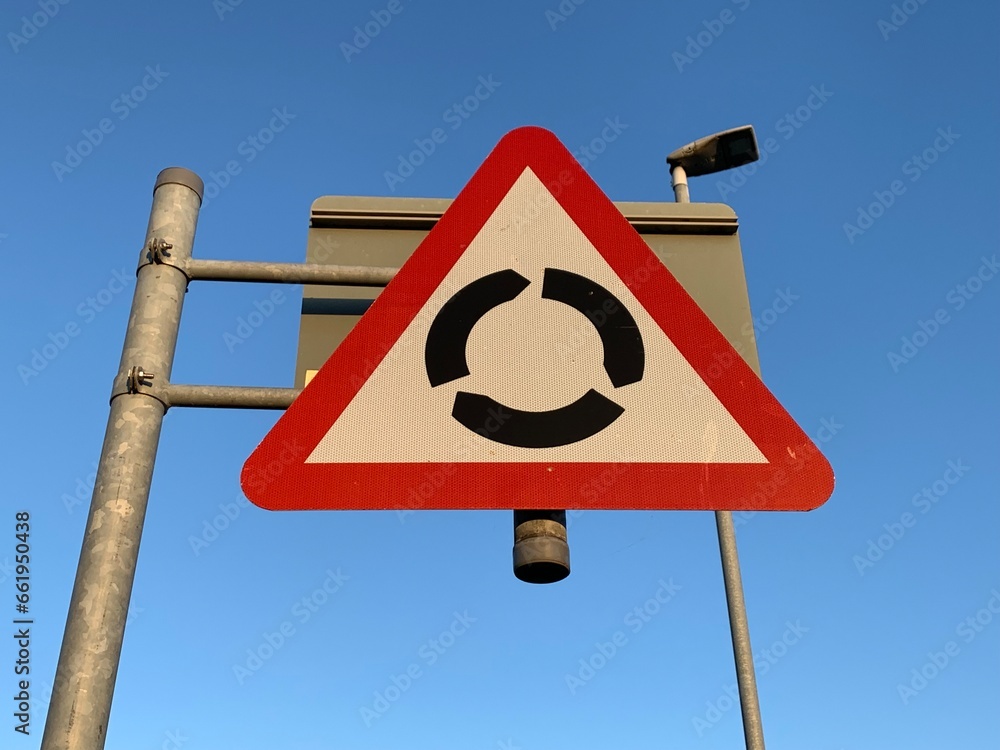 UK roundabout ahead warning sign against a clear blue sky, roundabout ...