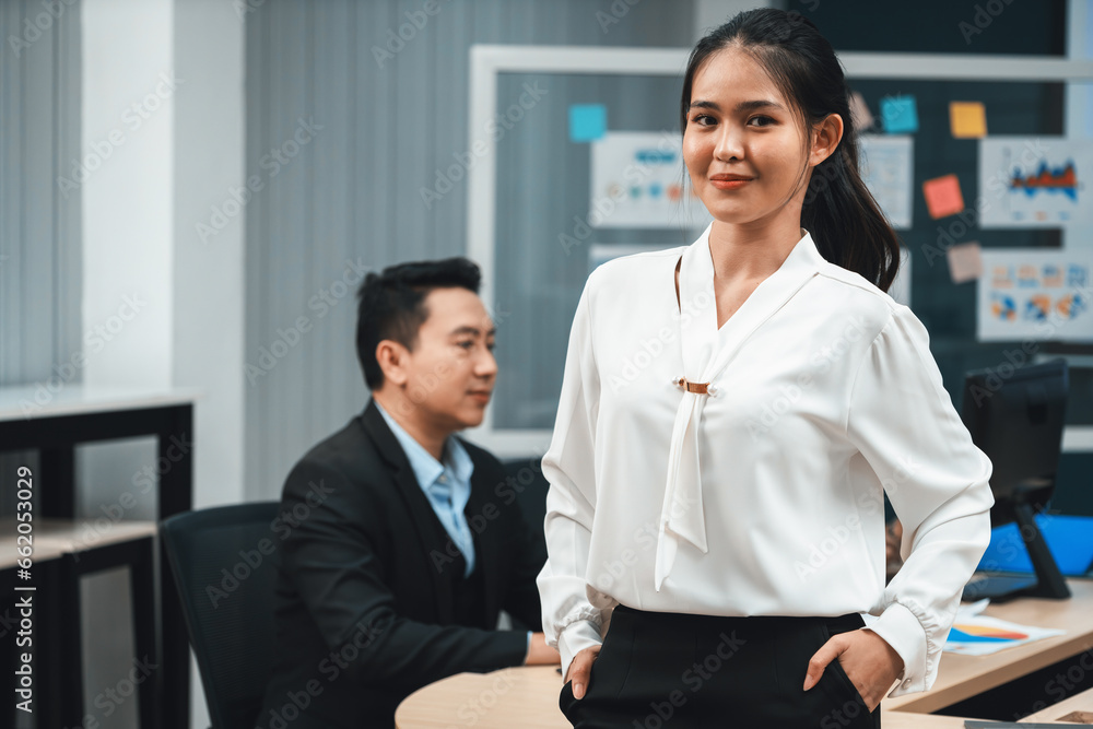 Successful businesswoman in white uniform standing in modern office in ...