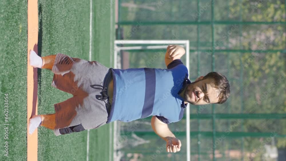 Vertical Video of Sporty dwarf young man flexing his shoulder muscles ...