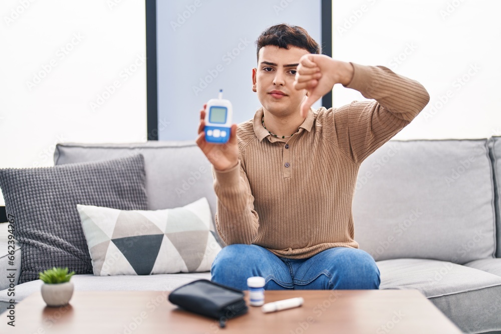 Non binary person using blood pressure monitor with angry face ...