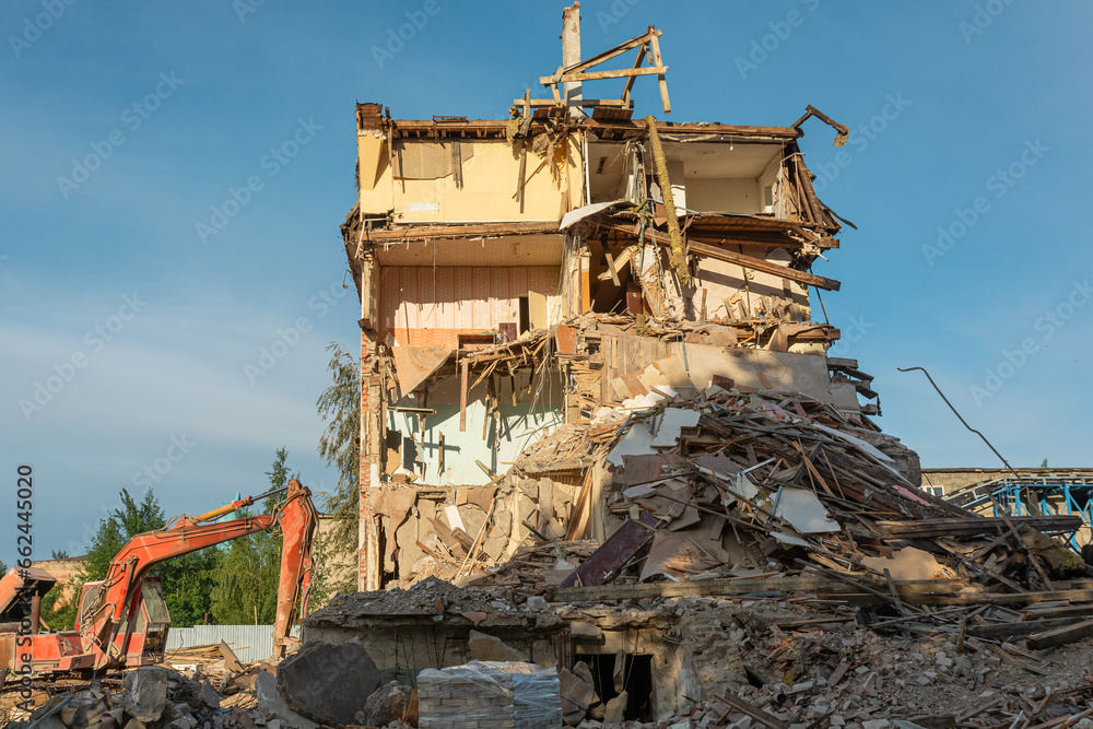 Demolition of ruined building. Excavator breaks old house damaged by ...