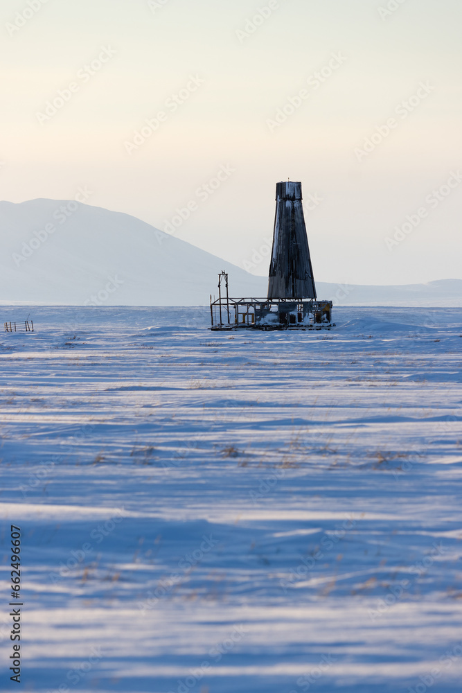 An old abandoned geological drilling rig in the snow-covered tundra ...