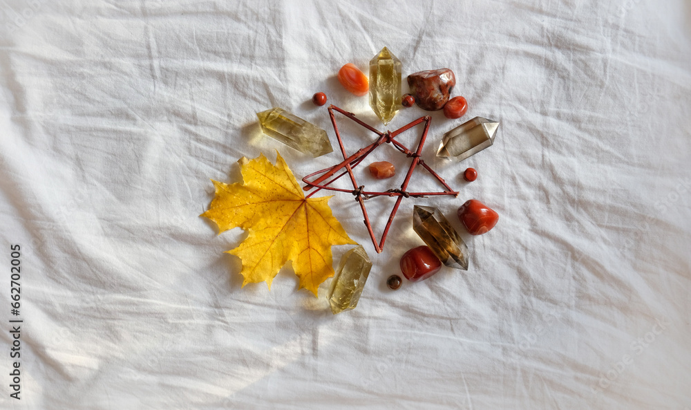 Crystal minerals, pentacle amulet, yellow maple leaf on abstract light ...