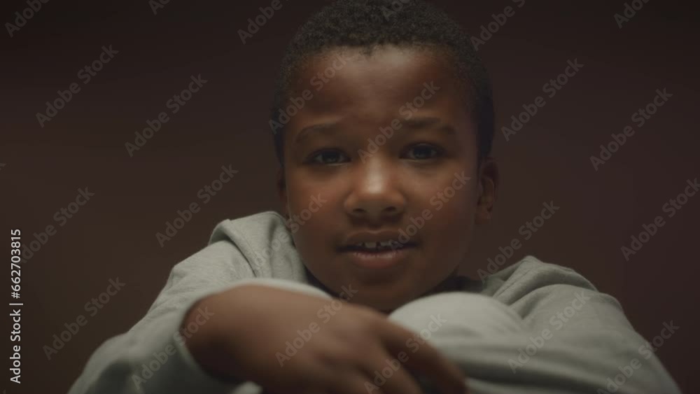 Zoom in portrait of scared African American little boy looking at ...
