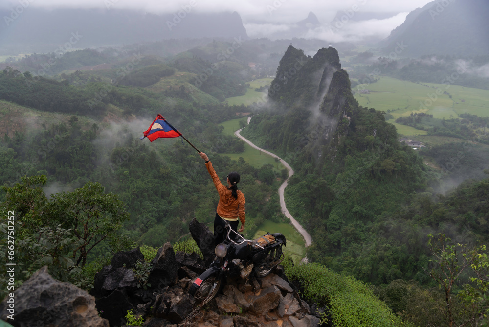 Tourist holding Lao flag on the Nam Xay Viewpoint, During the rainy ...