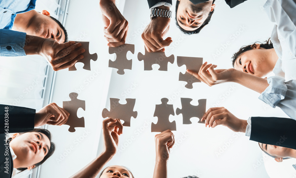 Multiethnic business people holding jigsaw pieces and merge them ...