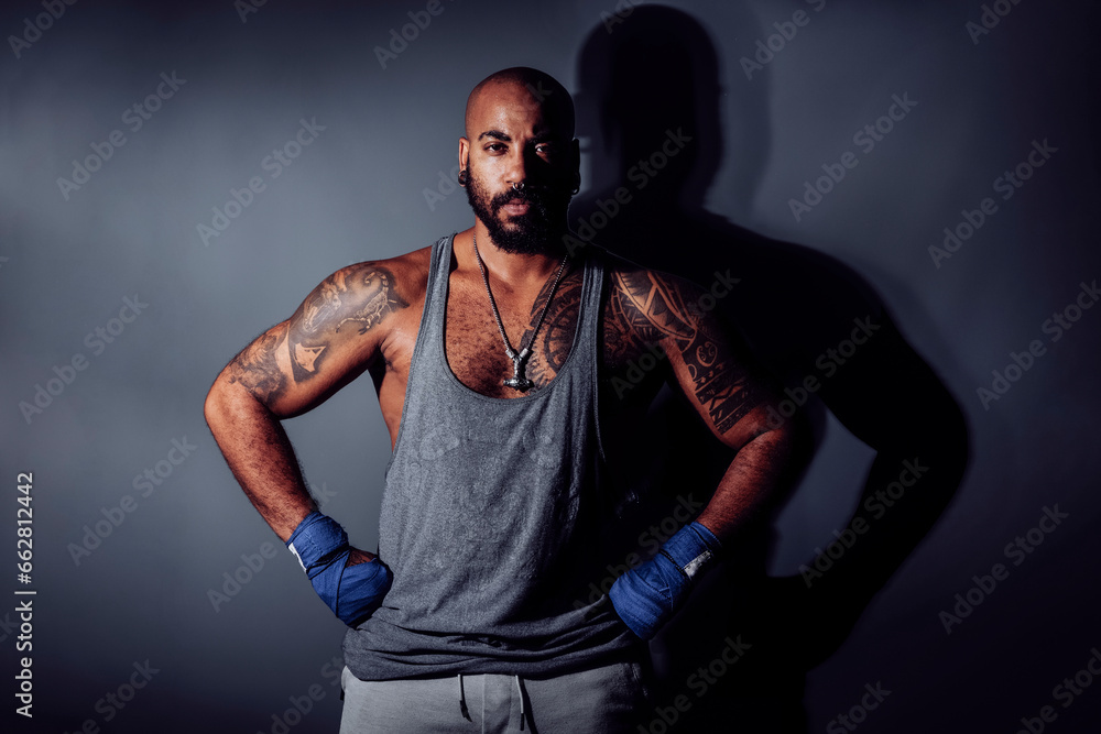 Muscular black man with bandages on his hands looks at camera in ...