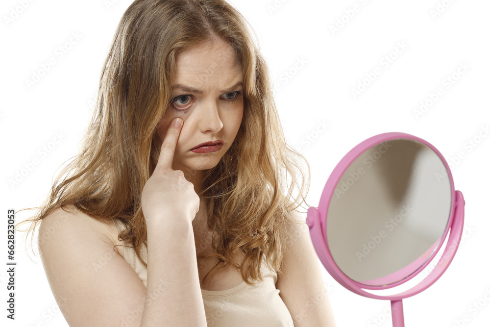 Young blond woman looking in the mirror nervous about the crack face ...