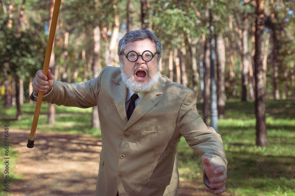 Funny old man with a stick. An elderly man with a walking stick with a ...