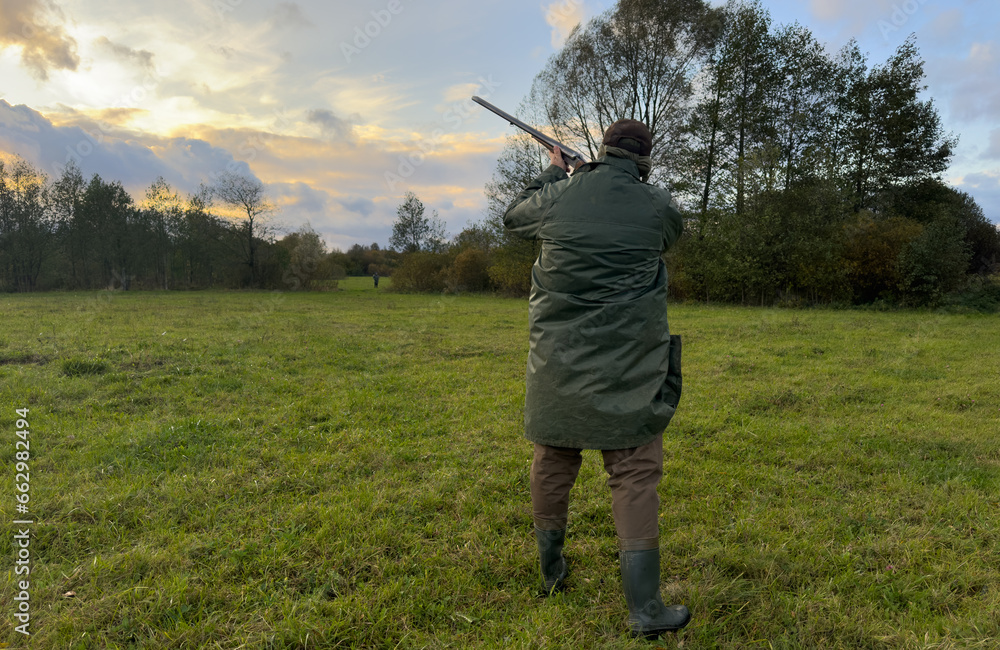 Hunter during hunt. A hunter walks through forest among trees in search ...