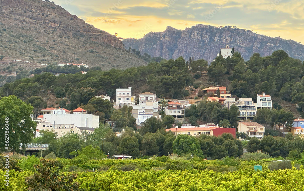 Houses on mountainside on Sunset. Residential buildings in town at ...