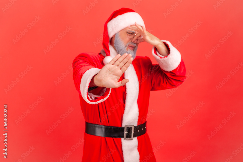 Santa claus in red costume pinching nose with fingers to avoid bad ...