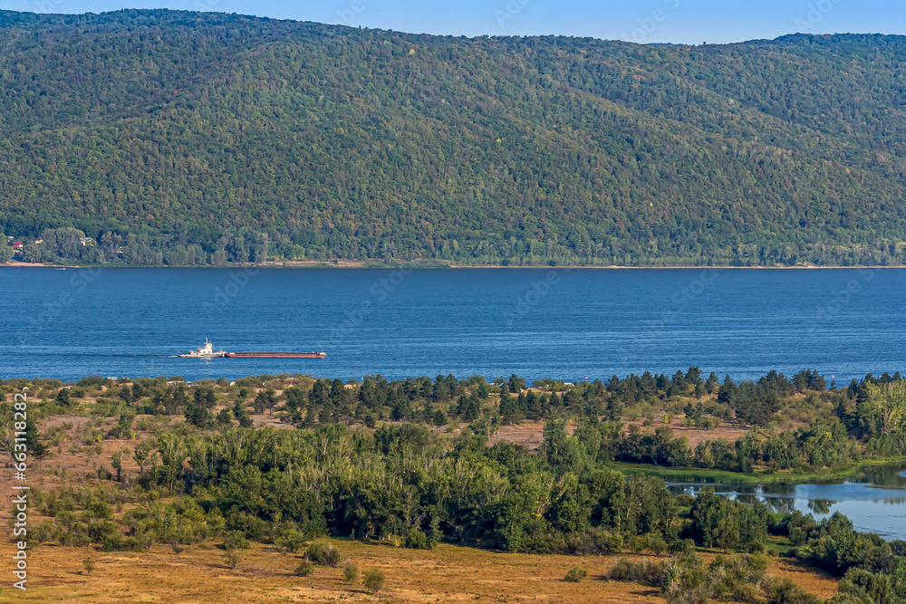 A tug pulls a barge along the Volga River near the city of Samara ...
