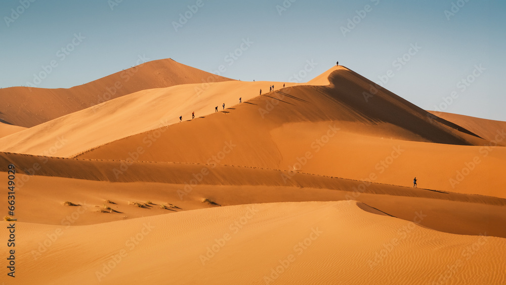 People climbing sand dunes in Sossusvlei area, Namib-Naukluft National ...