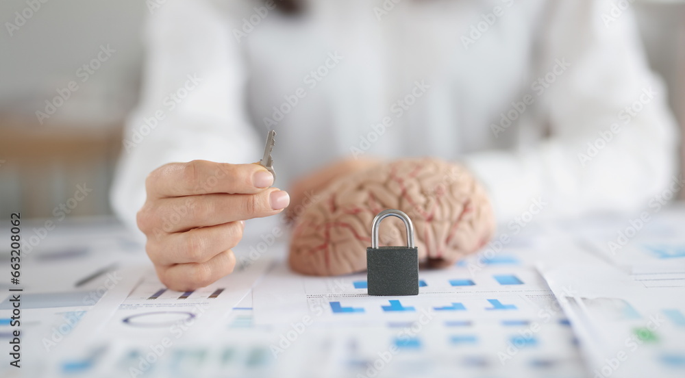 Close-up of woman hold key, lock and human brain on desk, symbol as key ...
