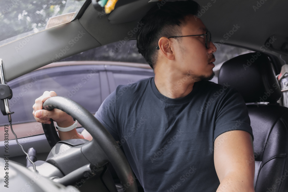 Asian Thai man with beard, wear eyeglasses and navy t-shirt, parking a ...
