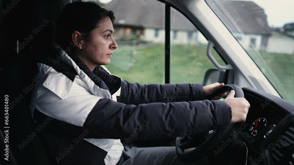 Fototapeta Female driver holding truck's steering wheel relocating to ... Fototapeta Female driver holding truck's steering wheel relocating to ...