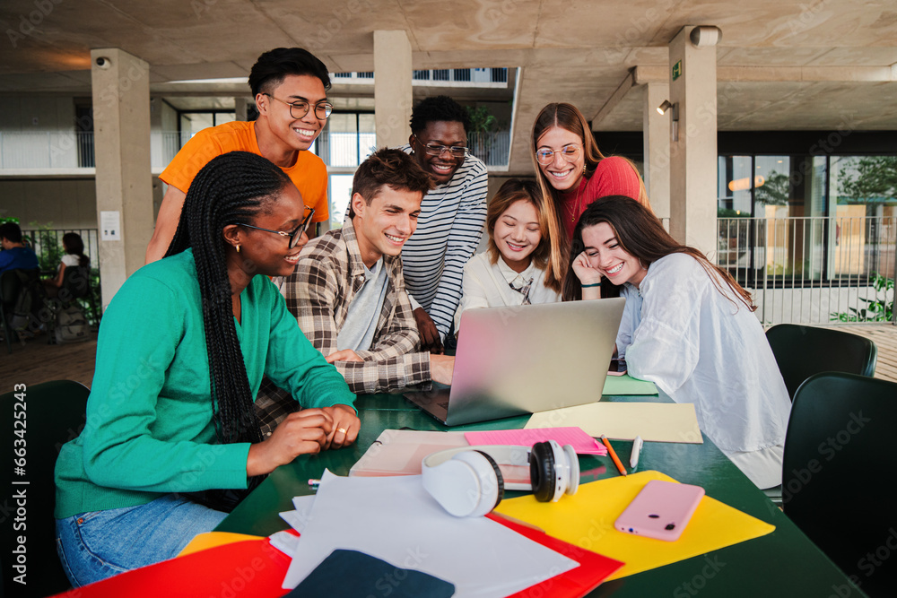 Big group of multiracial teenage students using laptop, working on ...