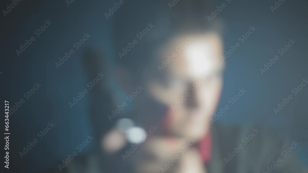 Focus pull shot of a man with a gun aiming and lowering his aim ...