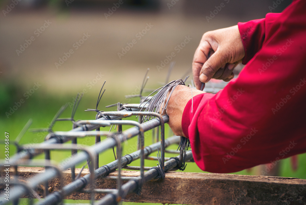 Men hands using pincer pliers iron wire reinforcement of concrete work ...