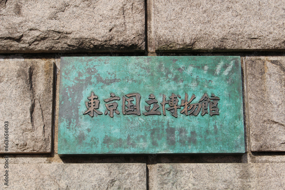 TOKYO, JAPAN - October 26, 2018: A bronze sign in Japanese on a wall ...