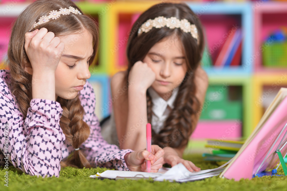Two school age kids doing their homework on floor at home. Brother and ...