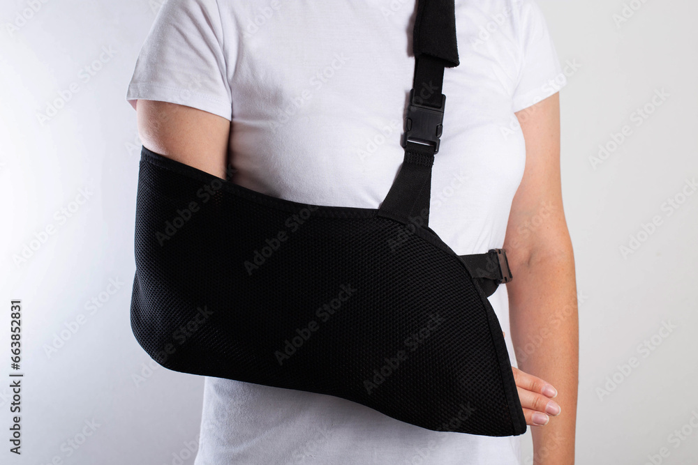 A girl in white with a black support bandage for her arm after a ...