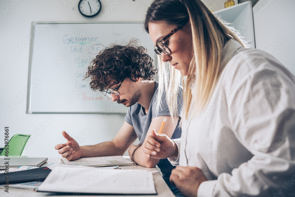 Two language learning students are focused on taking a test in their ...