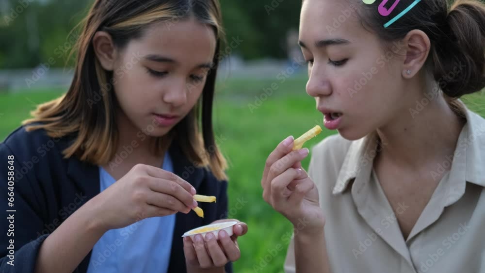 Cute children, two sisters eating French fries outdoors in summer ...