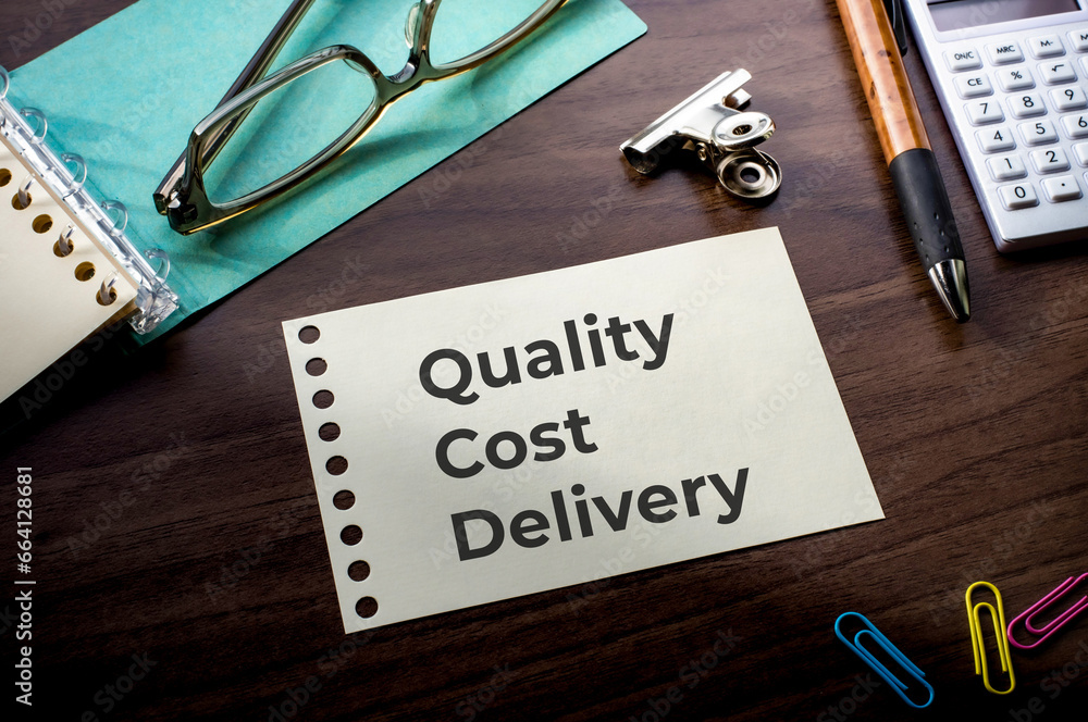 There is notebook with the word Quality Cost Delivery. It is as an eye ...