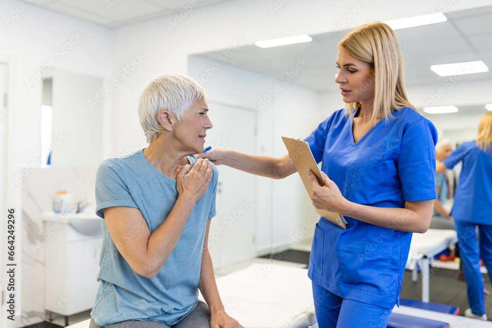 Woman doctor osteopath in medical uniform fixing senior woman patients ...
