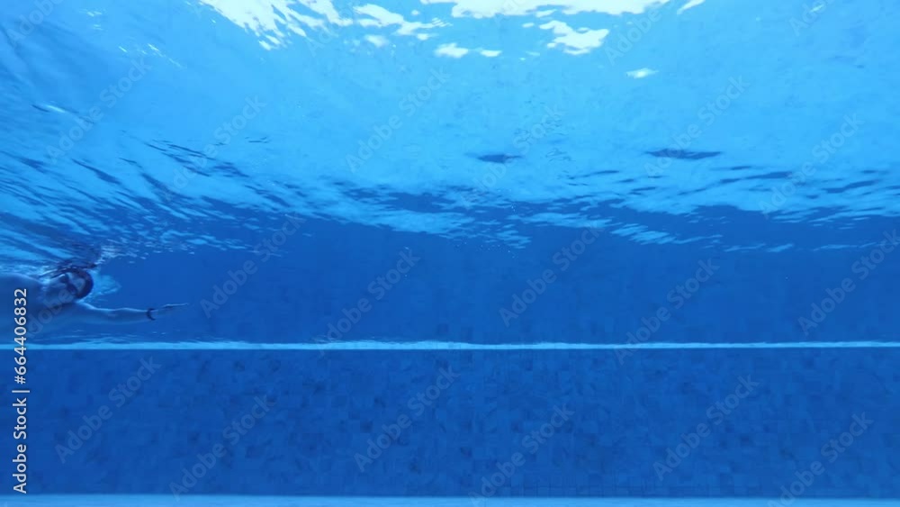 Slow motion of sportsman swimming in crawl style in the pool wearing ...