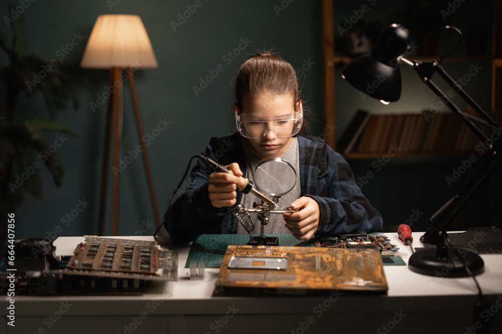 Smart young teenage girl studying electronics soldering wires and ...