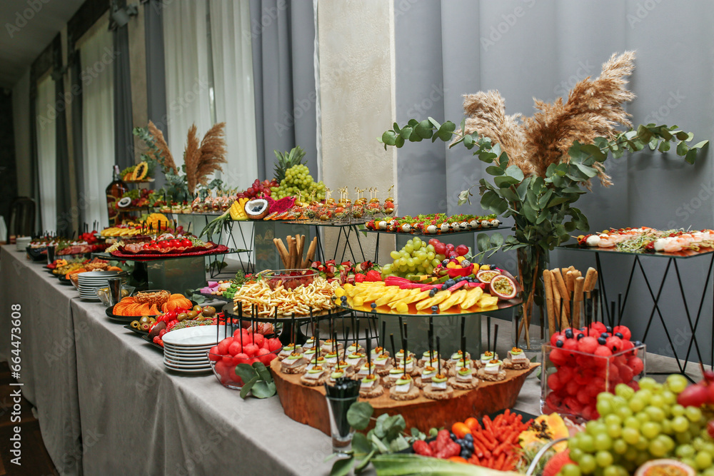 catering buffet table with snacks and appetizers. Set of varios fruits ...