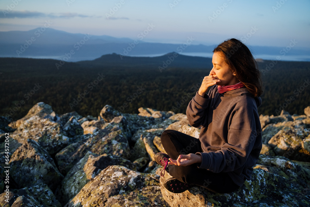 Breathing exercises in yoga, girl sitting in lotus position, pinching ...
