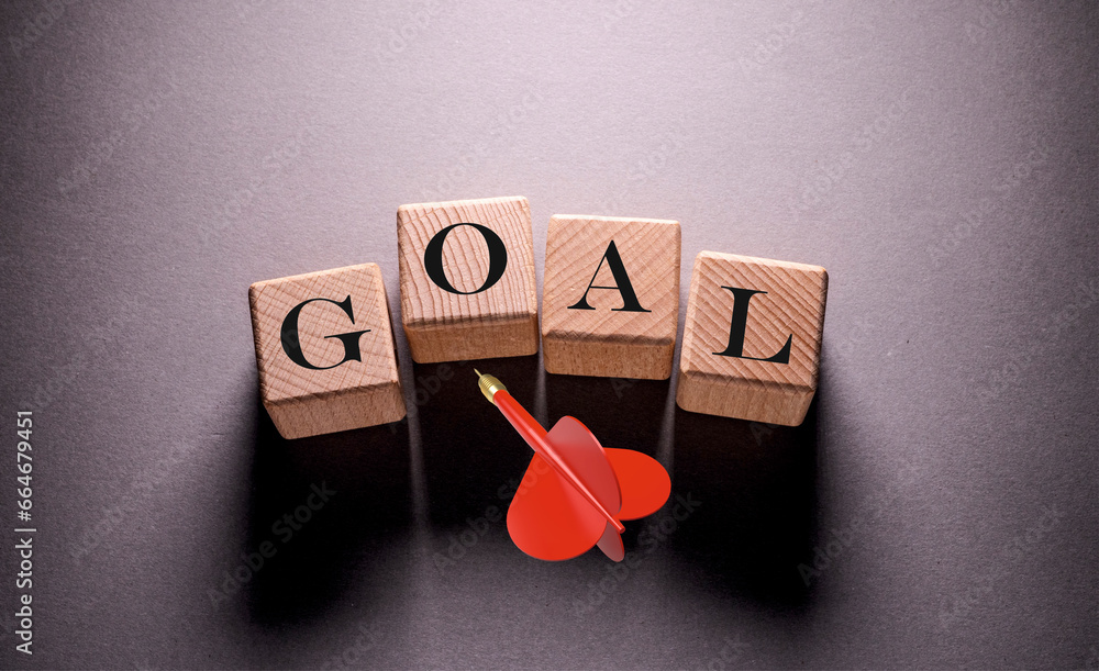 Cubos de madera con las letras Goal y dardo rojo. Concepto de dar en ...
