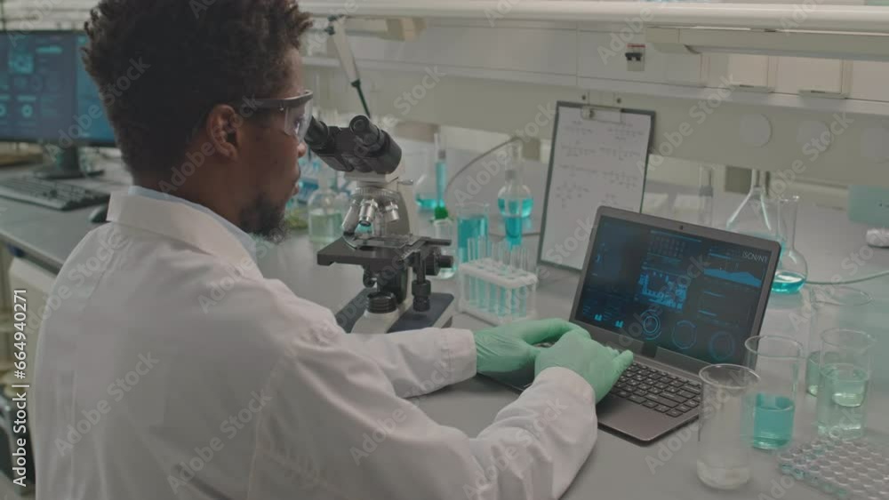 Waist up of young African American male scientist in white lab coat ...