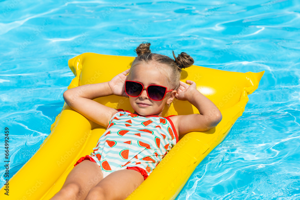 Cute little girl lying on inflatable mattress in swimming pool with ...