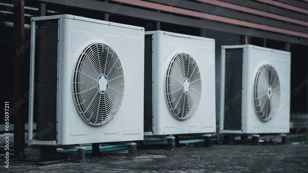 Air conditioner compressor installed on the wall of a building, along ...