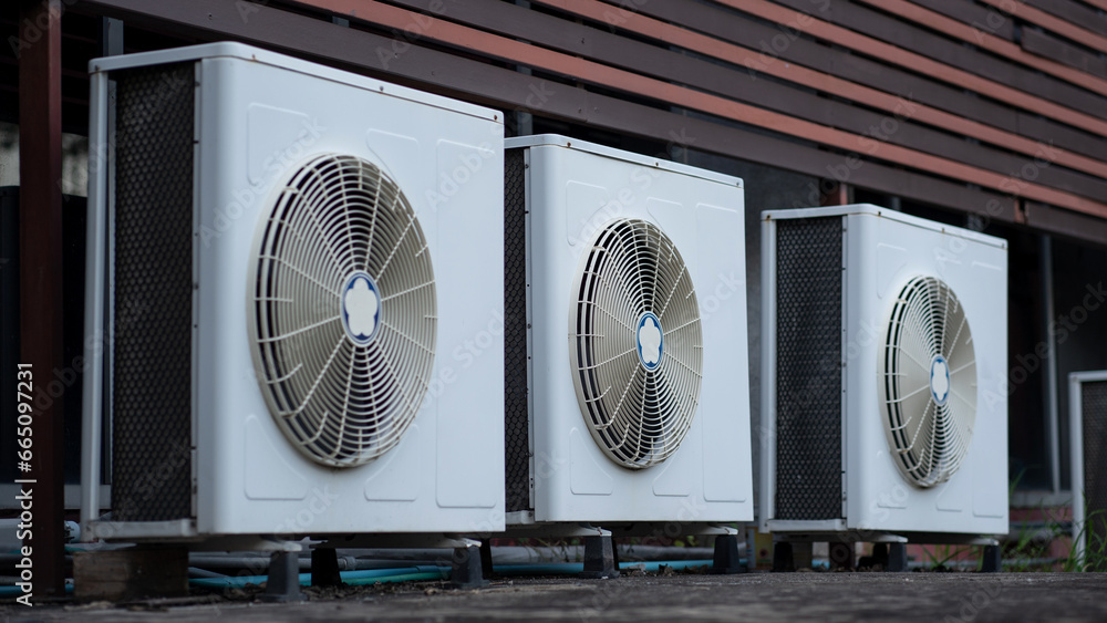Air conditioner compressor installed on the wall of a building, along ...