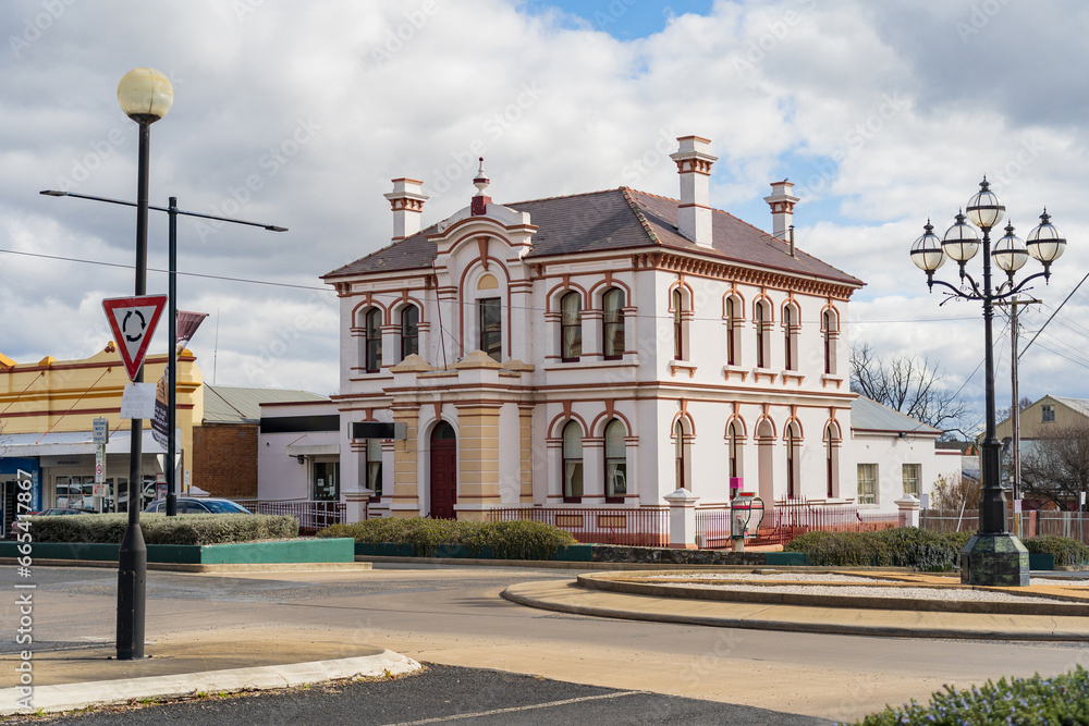 An historic two storey bank building alongside a roundabout with an old ...