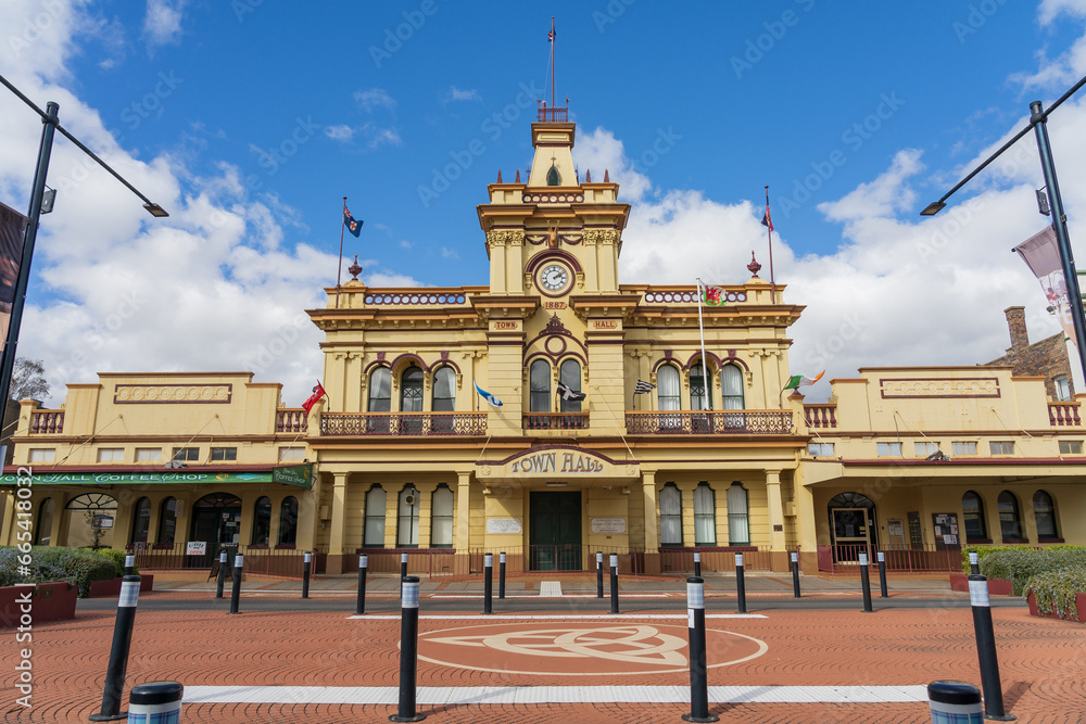 A grand historic Town Hall with a clock tower behind rows of bollards ...