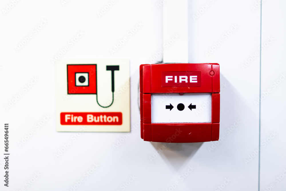 Red fire alarm button with its respective warning sign on the back ...