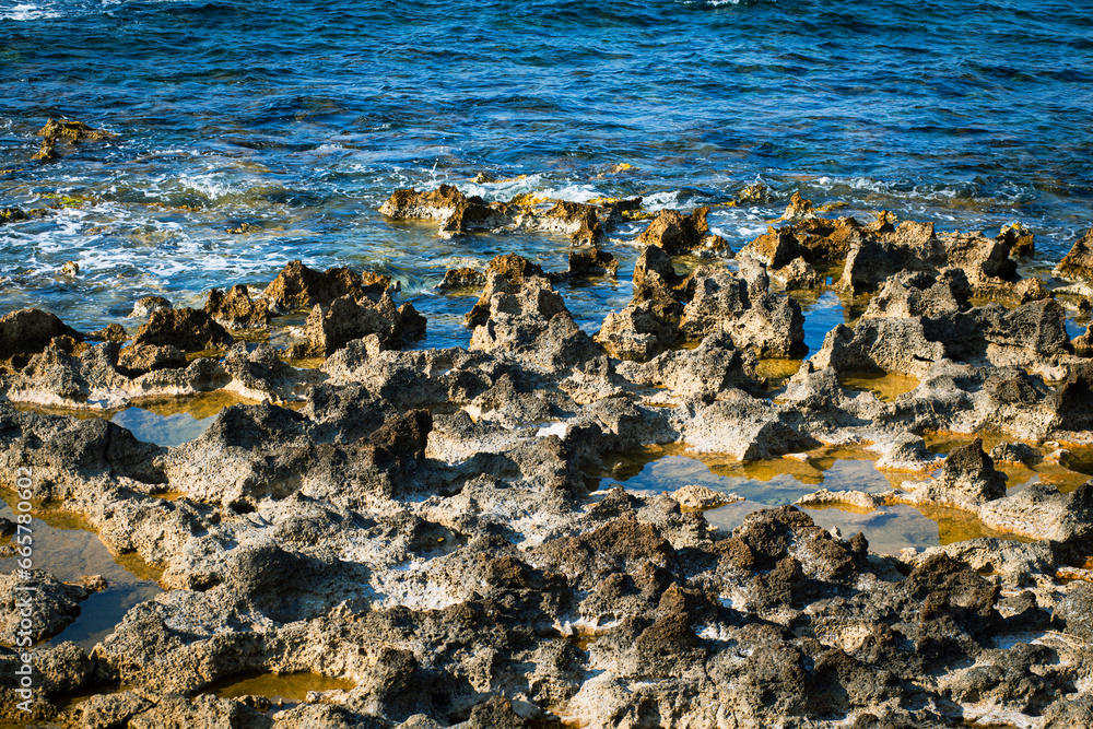 Sharp rocks on a shallow coastal landscape in the shore of a beach in ...