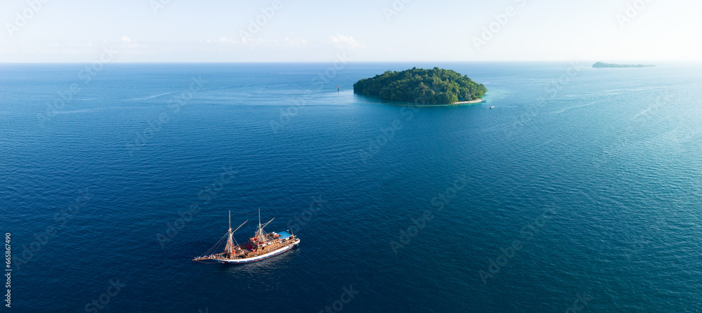 An idyllic, tropical island, surrounded by coral reef, is found in the ...