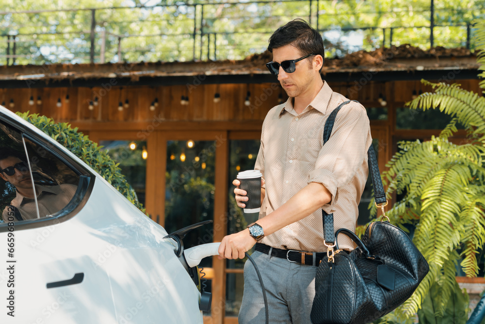Eco friendly man and sustainable urban commute with EV electric car ...