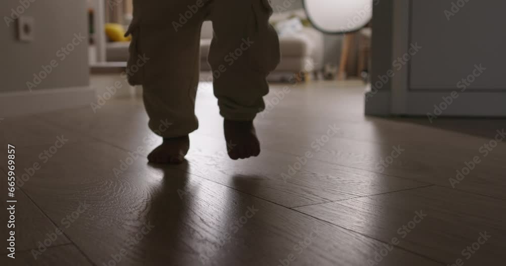 Legs of toddler walking around house. Baby confidently skillfully walks ...