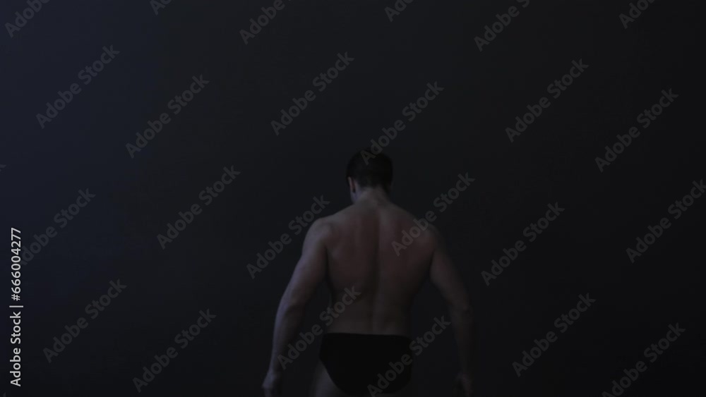 A muscular athlete in an epic pose, fog and smoke on the background ...